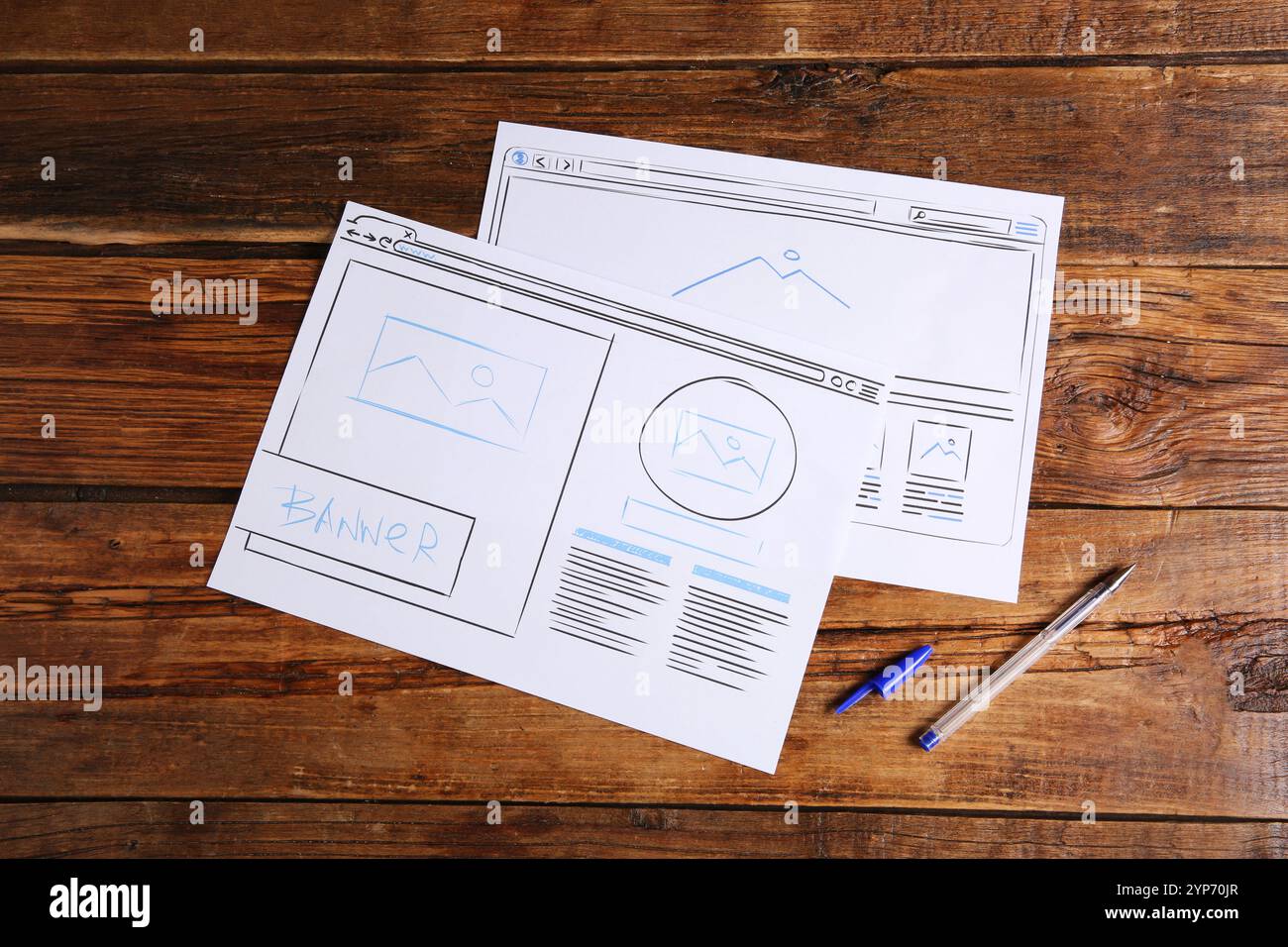 Developing UI design. Sketches of website wireframes and pen on wooden ...