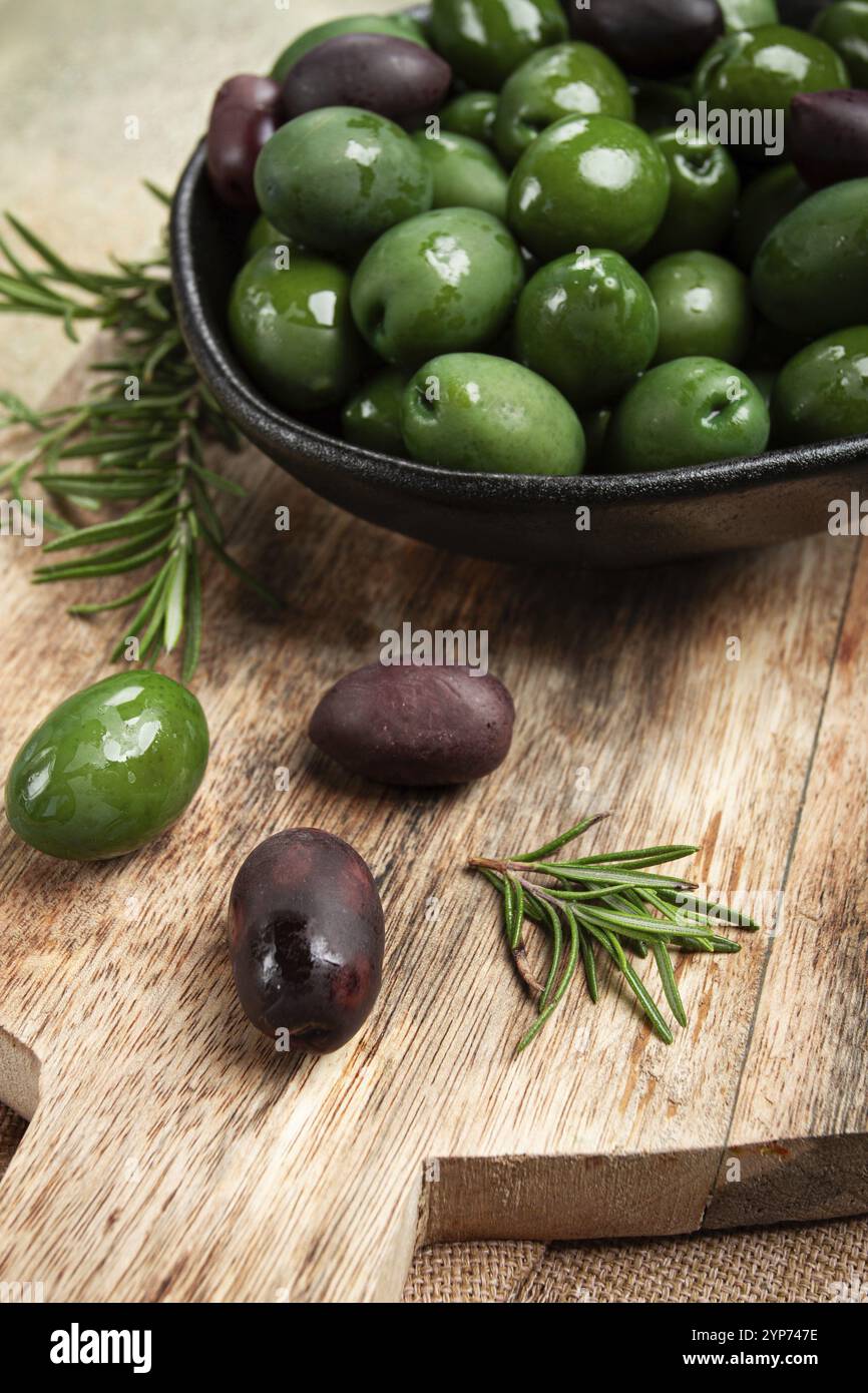 Chalkidiki olives, classic Greek green olives, in a bowl on a cutting ...