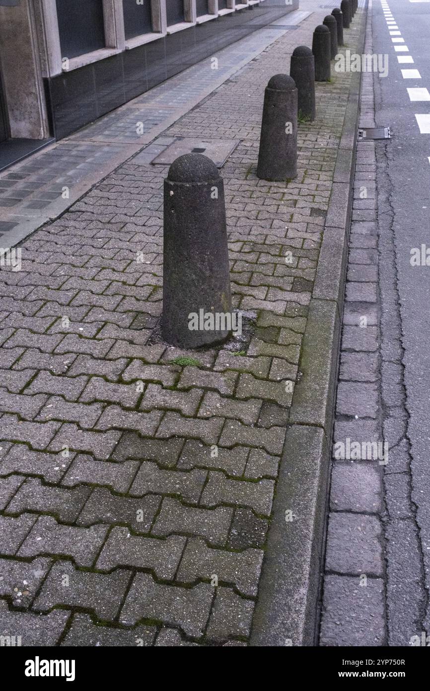 A row of stone bollards along a paved urban sidewalk Stock Photo - Alamy