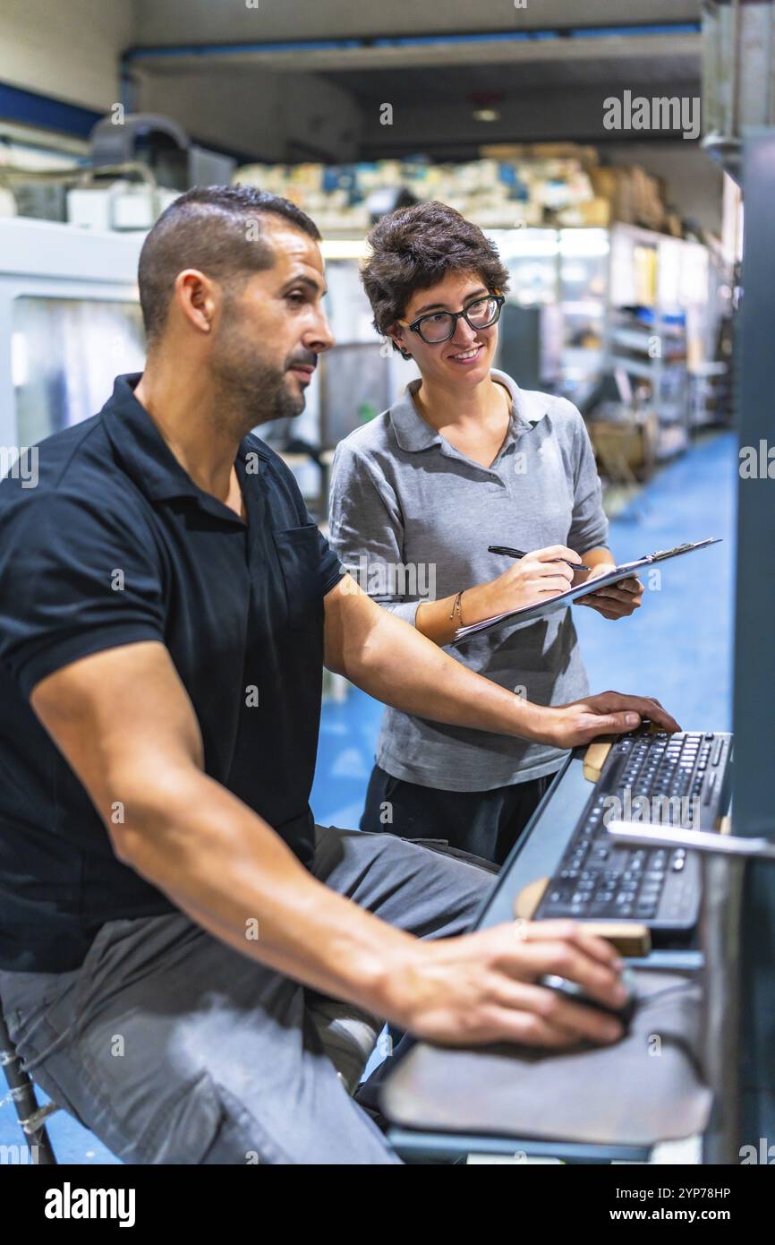 Vertical photo of a male engineer showing computer screen data to ...