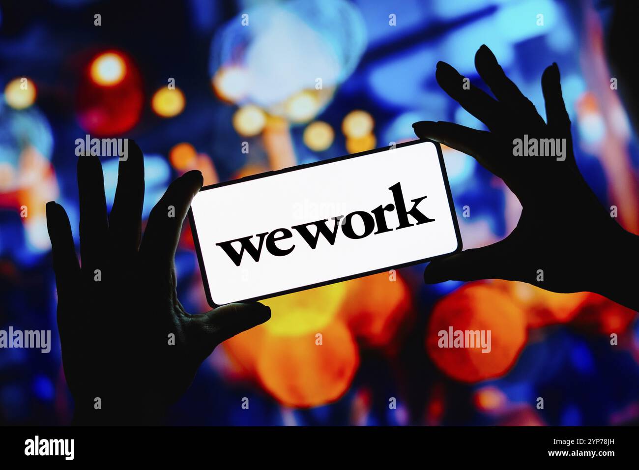 In this photo illustration, the WeWork logo is displayed on a ...