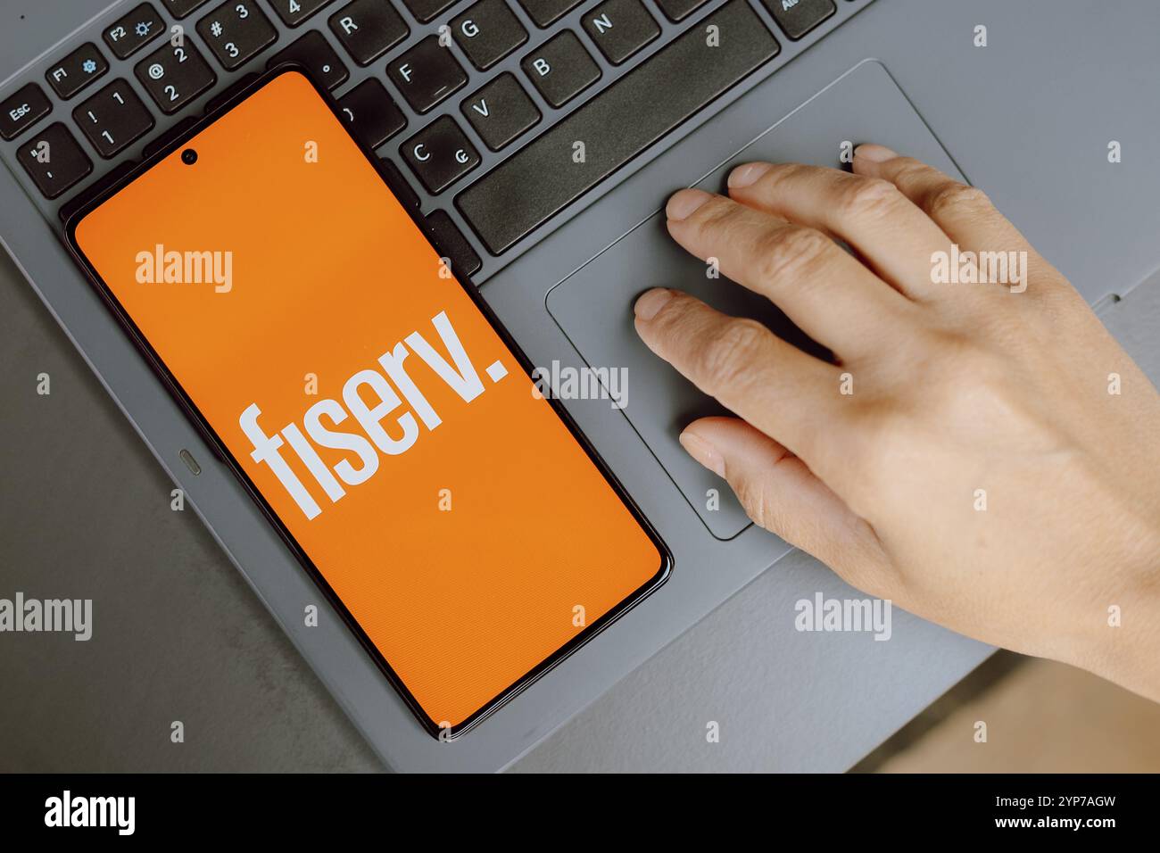 In this photo illustration, the Fiserv logo is displayed on a ...