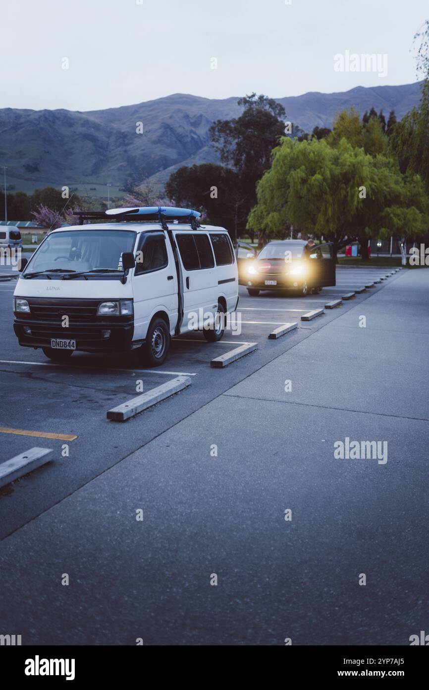 Two cars in a quiet car park in a mountainous landscape, Milford Sound ...