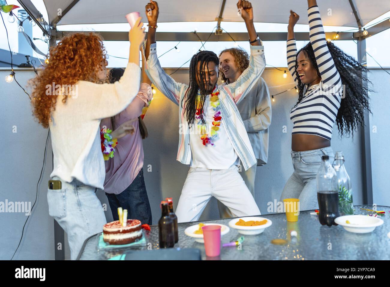 Multi-ethnic friends with Hawaiian necklaces and casual clothes raising ...