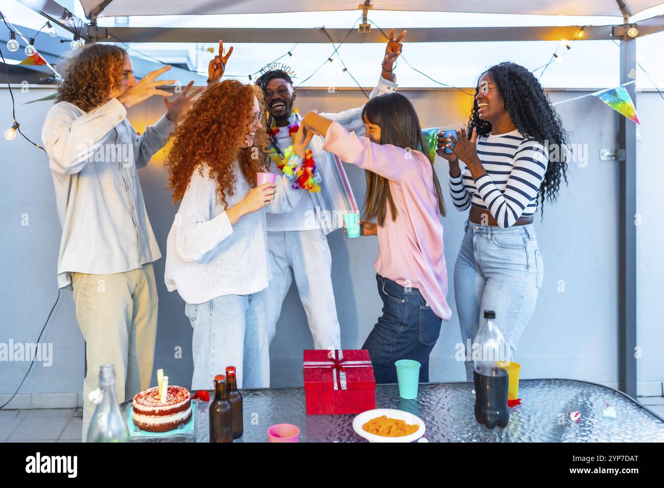 Happy multiracial group of friends dancing celebrating birthday party ...