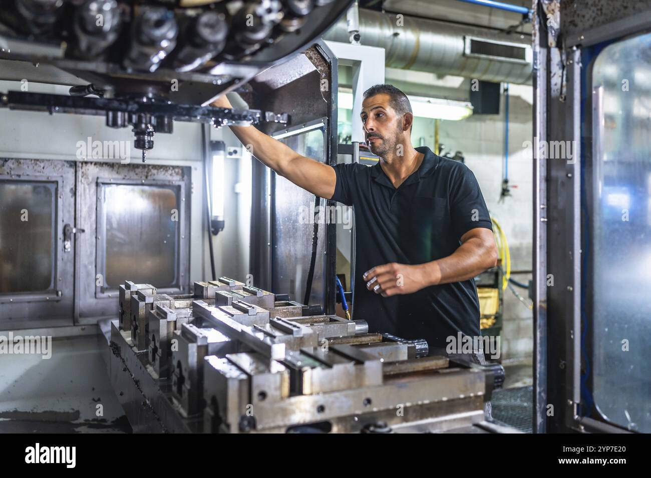 Male caucasian technician working with milling machine in a cnc ...