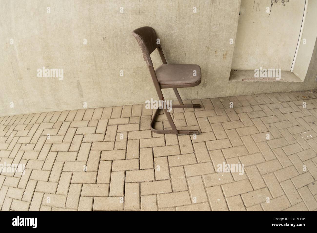 Chair on paving stones in front of house wall Stock Photo - Alamy