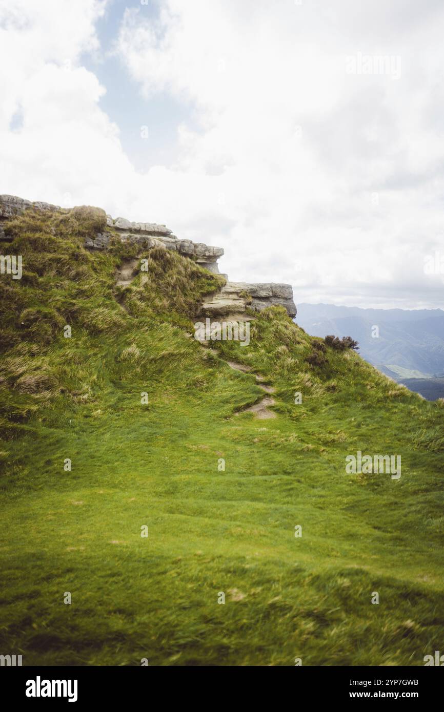 A grassy path leads along a rocky ledge under a cloudy sky, Bells Rock ...
