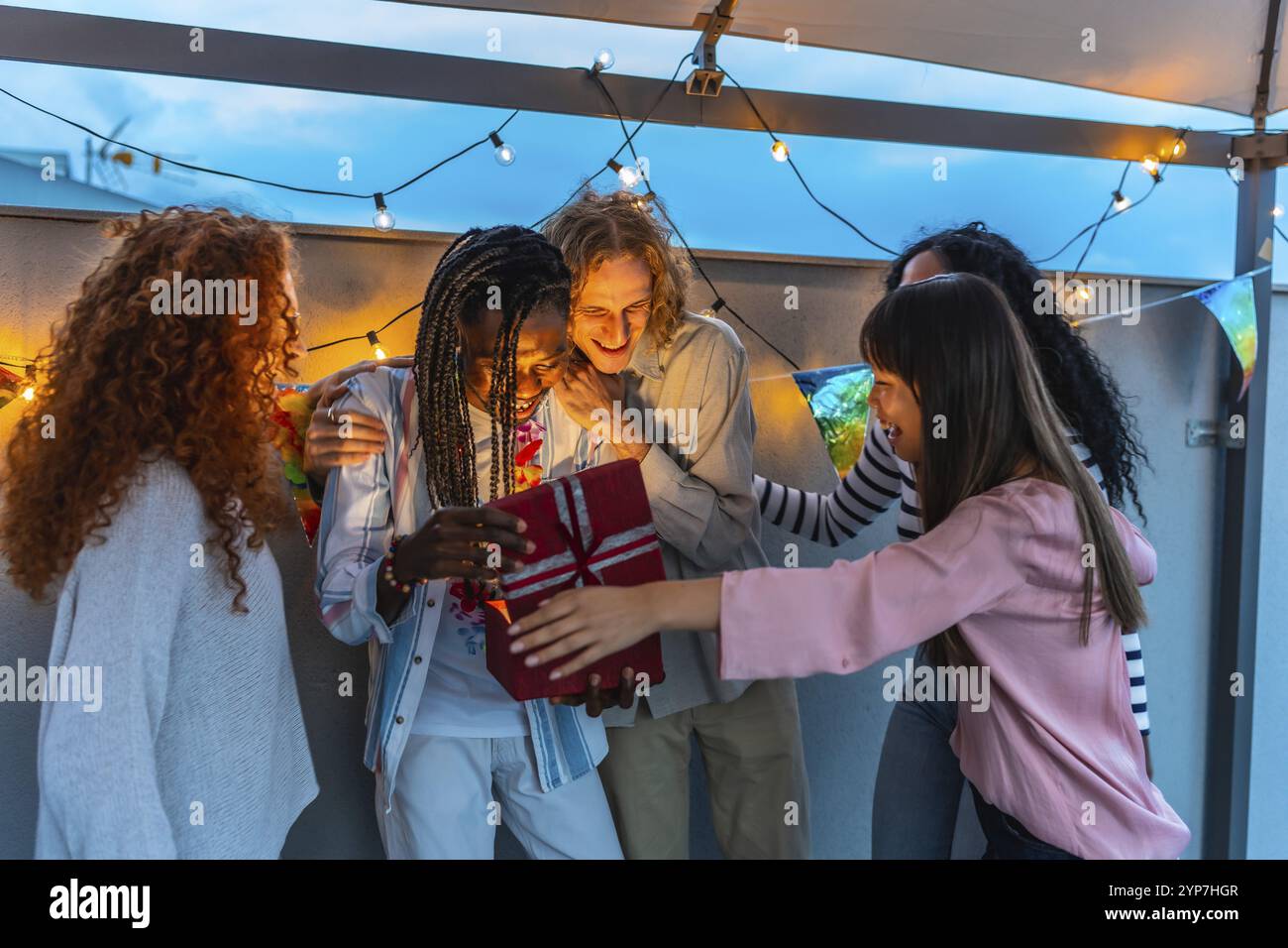 Happy millennial multi-ethnic friends celebrating birthday party in an ...