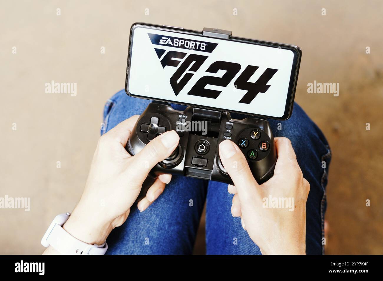 In this photo illustration, a person playing on a joystick and the EA ...