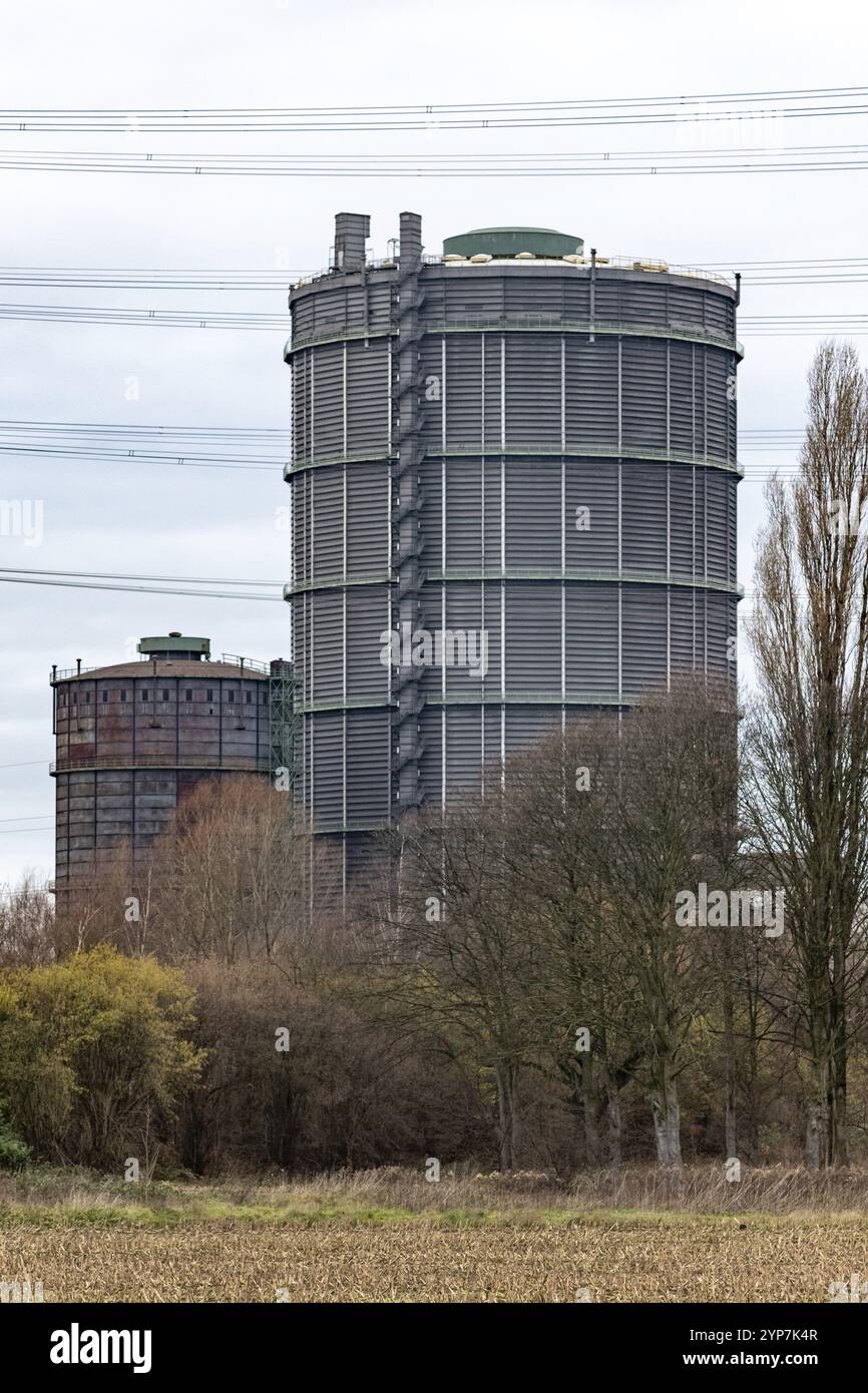 Two large industrial silos standing amidst a natural setting during an ...