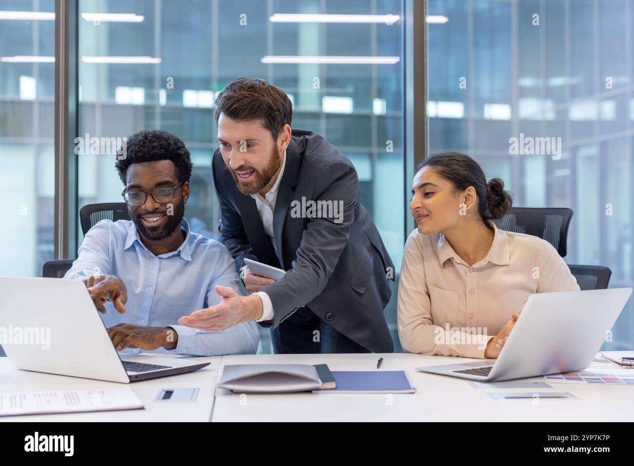 Diverse business team collaborating on project in modern office. Group ...