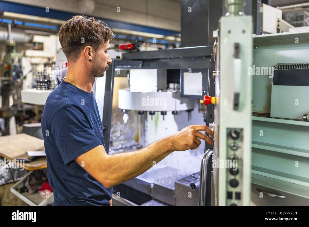 Man using mechanical machine to mold plastic parts in a cnc factory ...
