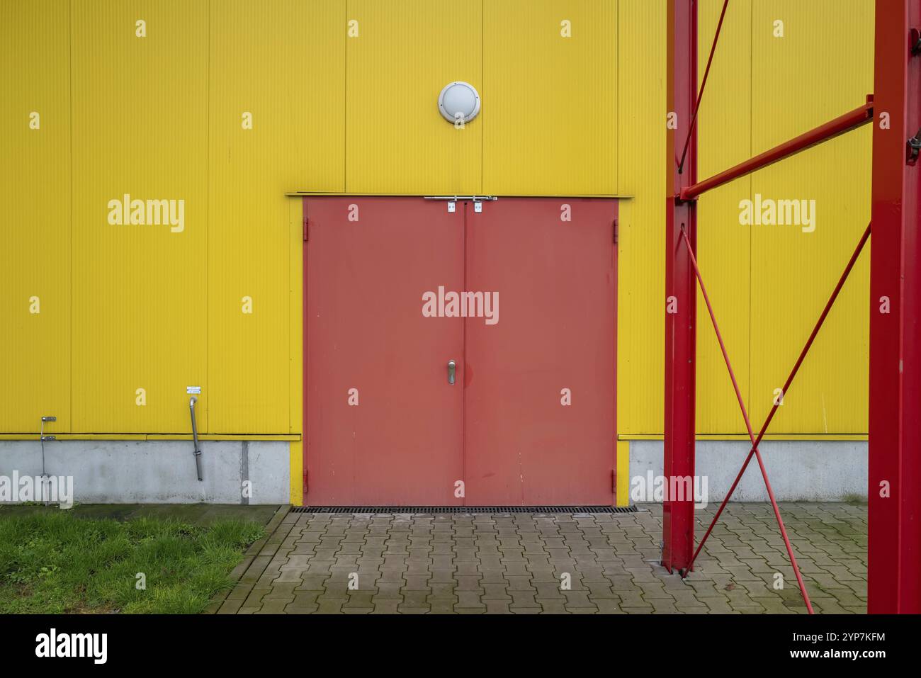 Large red metal door in yellow house wall Stock Photo - Alamy