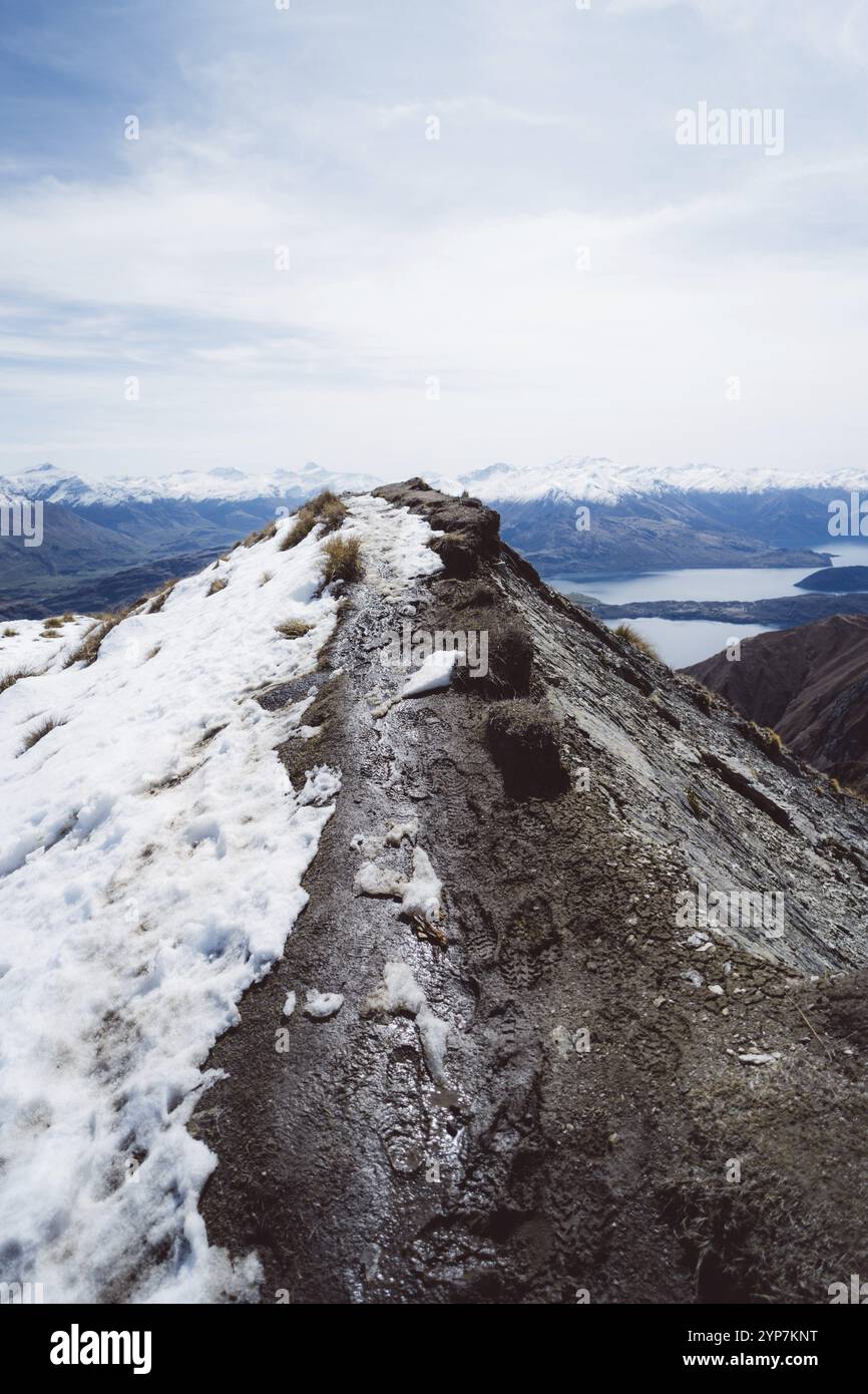 Snowy mountain peak with impressive views of a lake and mountain ranges ...