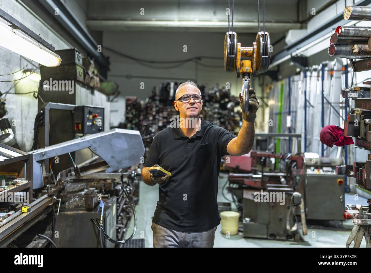 Male mature worker using an electric crane in a metal workshop Stock Photo - Alamy