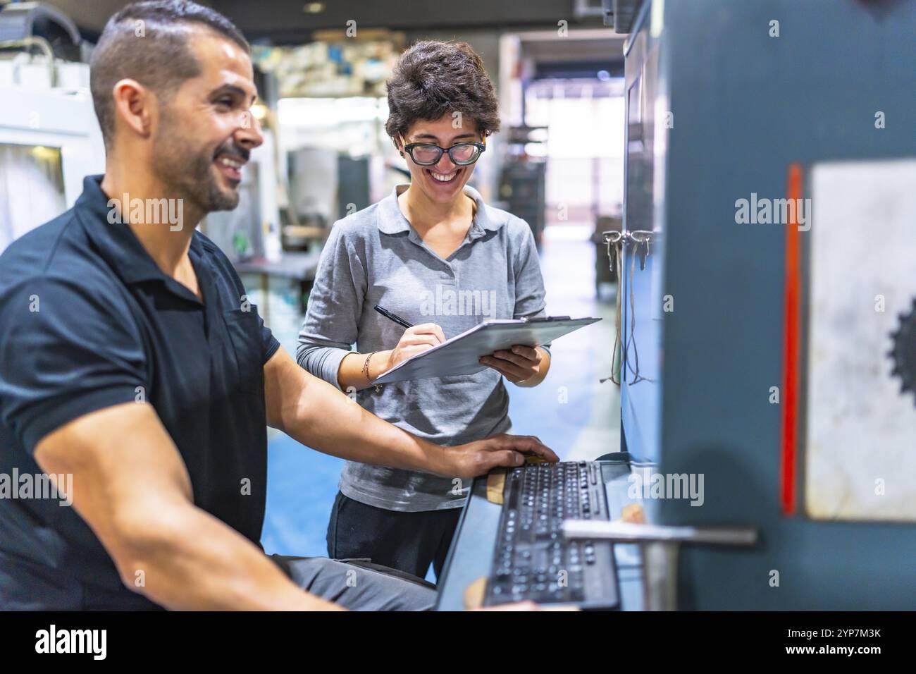 Engineer and manager talking while using computer in a cnc metallurgic ...
