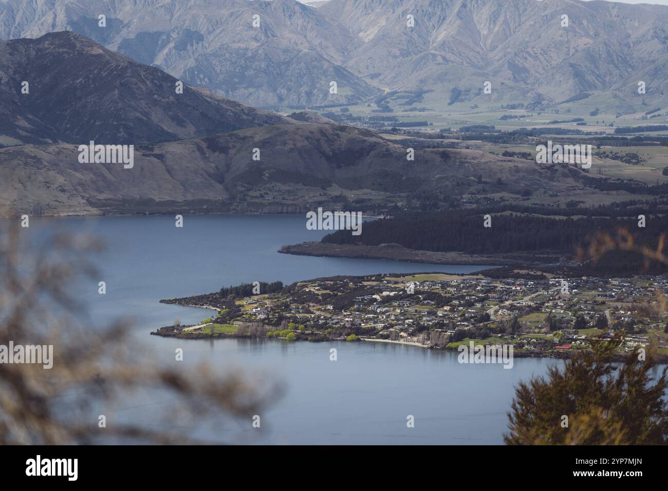 Landscape with a lakeside town surrounded by mountains and forests ...