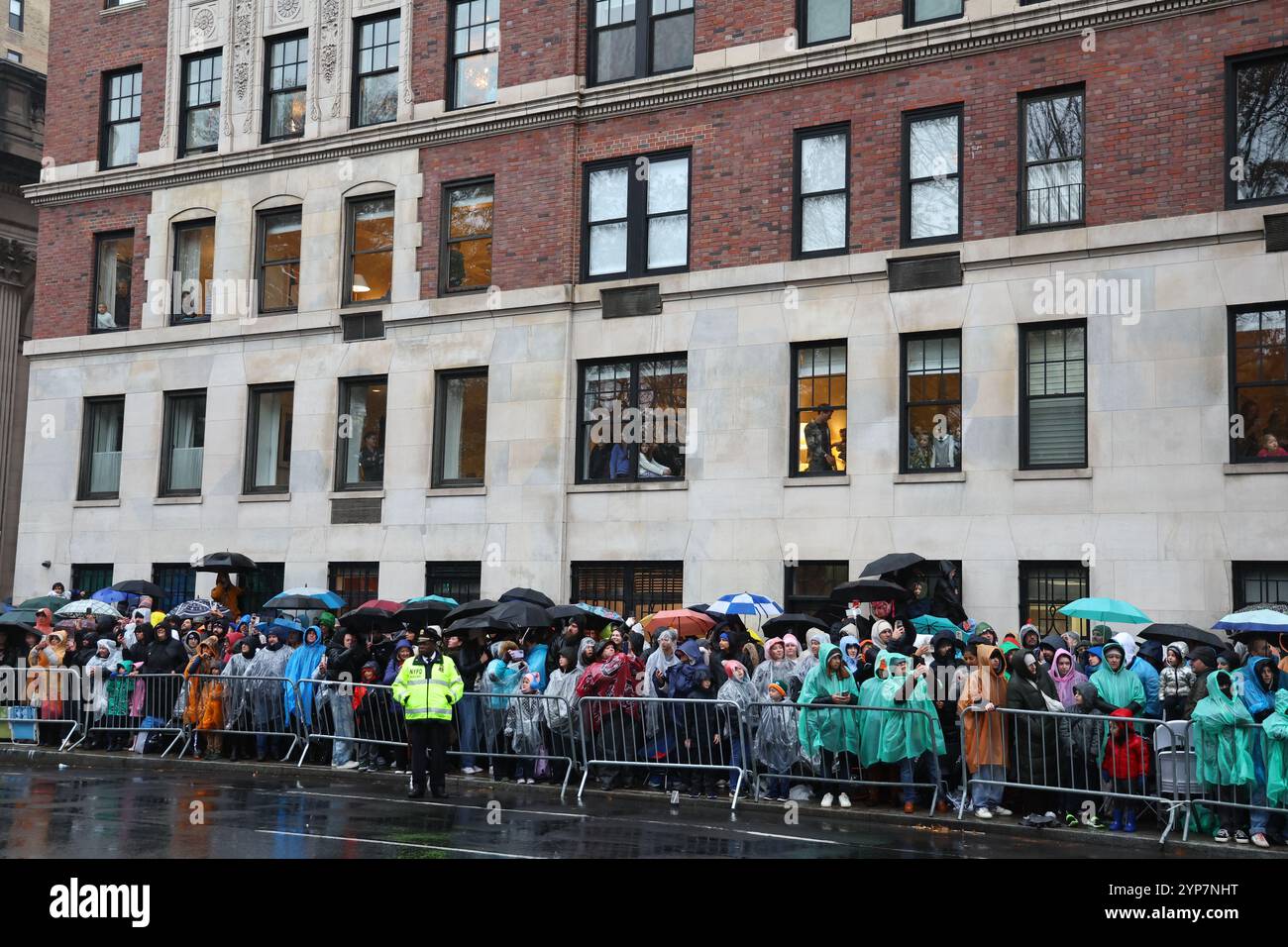 Crowds brave the cold rain as balloons, floats and performers head down ...