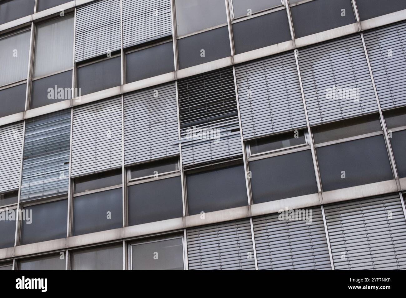 Grid-like pattern of a building's glass facade with various window ...