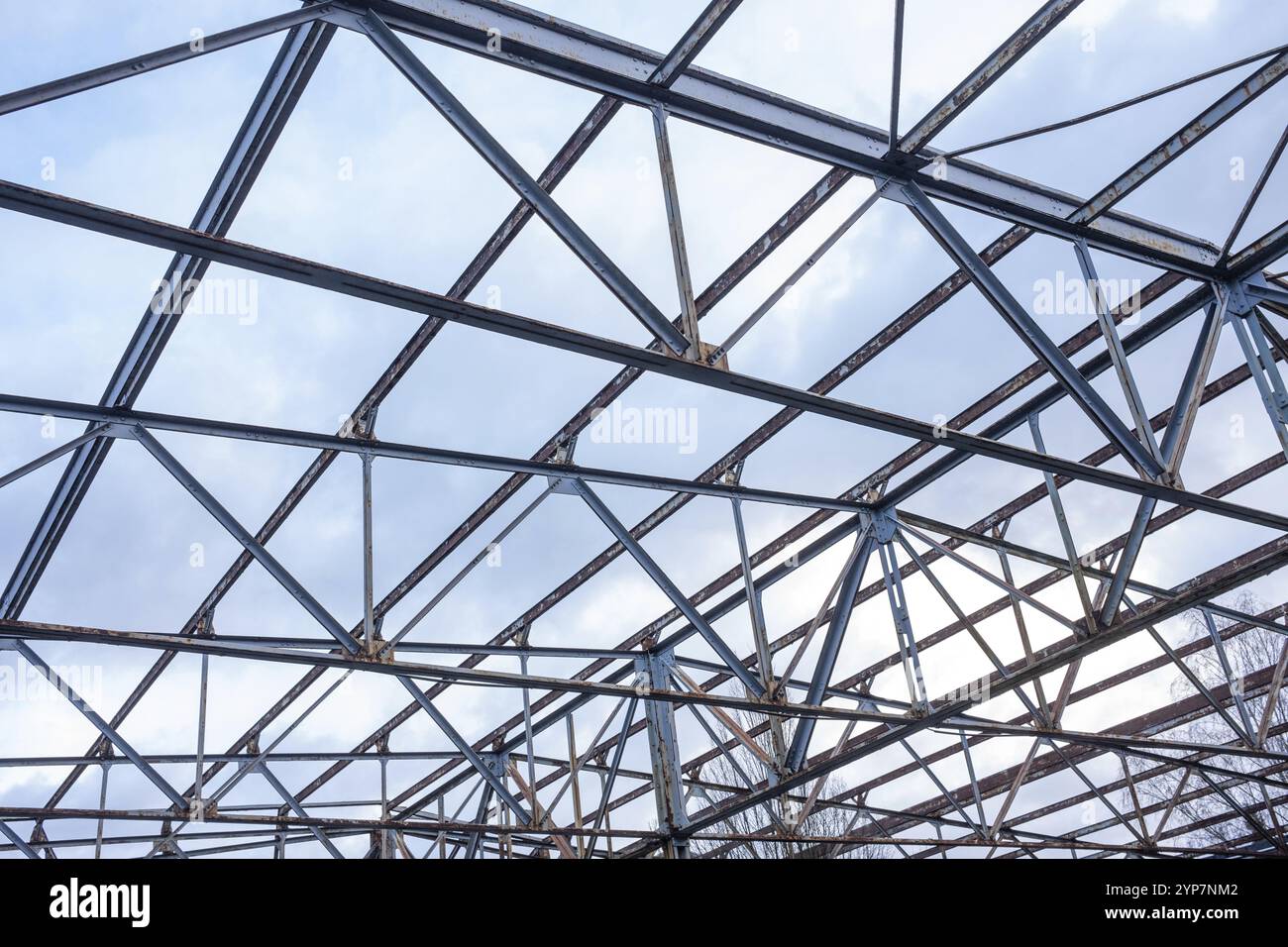 Open roof structure with metal trusses against a clear sky, under ...