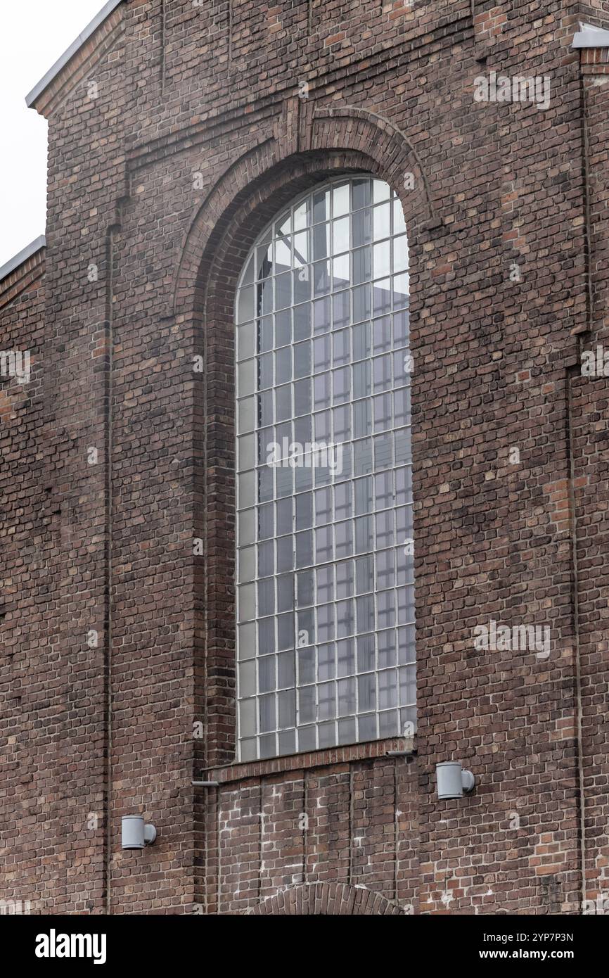A large arched window on a historic brick building, displaying ...