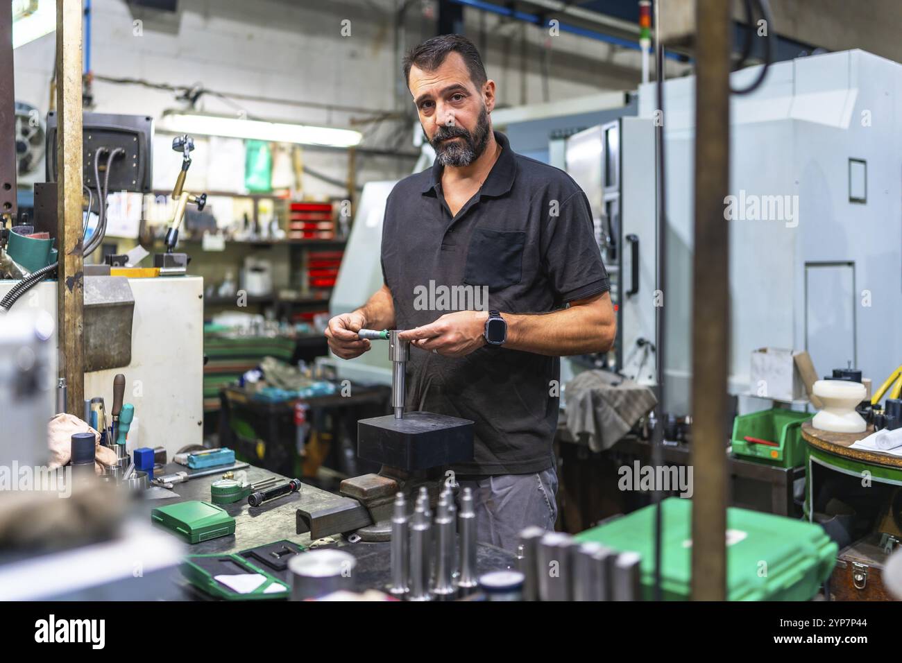 Male caucasian operator performing quality control on metal pieces in ...