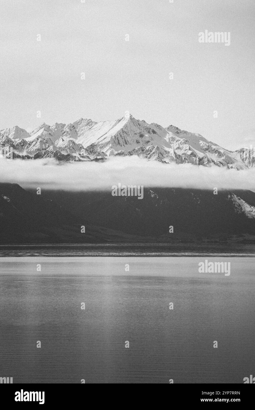 Sublime snow-capped mountains under a blanket of clouds in monochrome ...