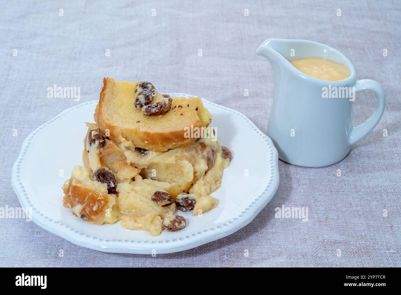 Serving of bread and butter pudding with a jug of custard Stock Photo ...