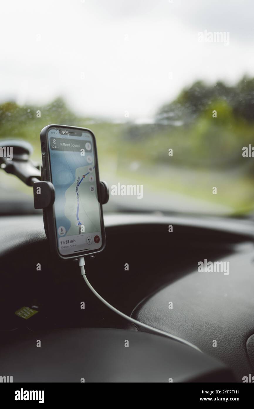 Smartphone shows a navigation route on the dashboard of a car, Milford ...