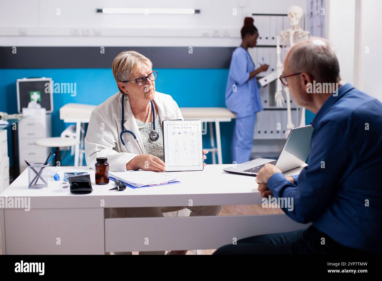 Senior doctor discussing treatment plans on tablet with elderly white ...