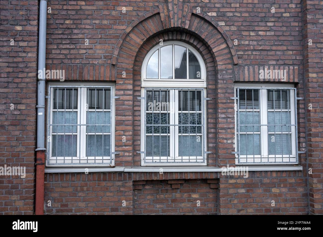 Brick building with three arched windows, each secured with bars Stock ...