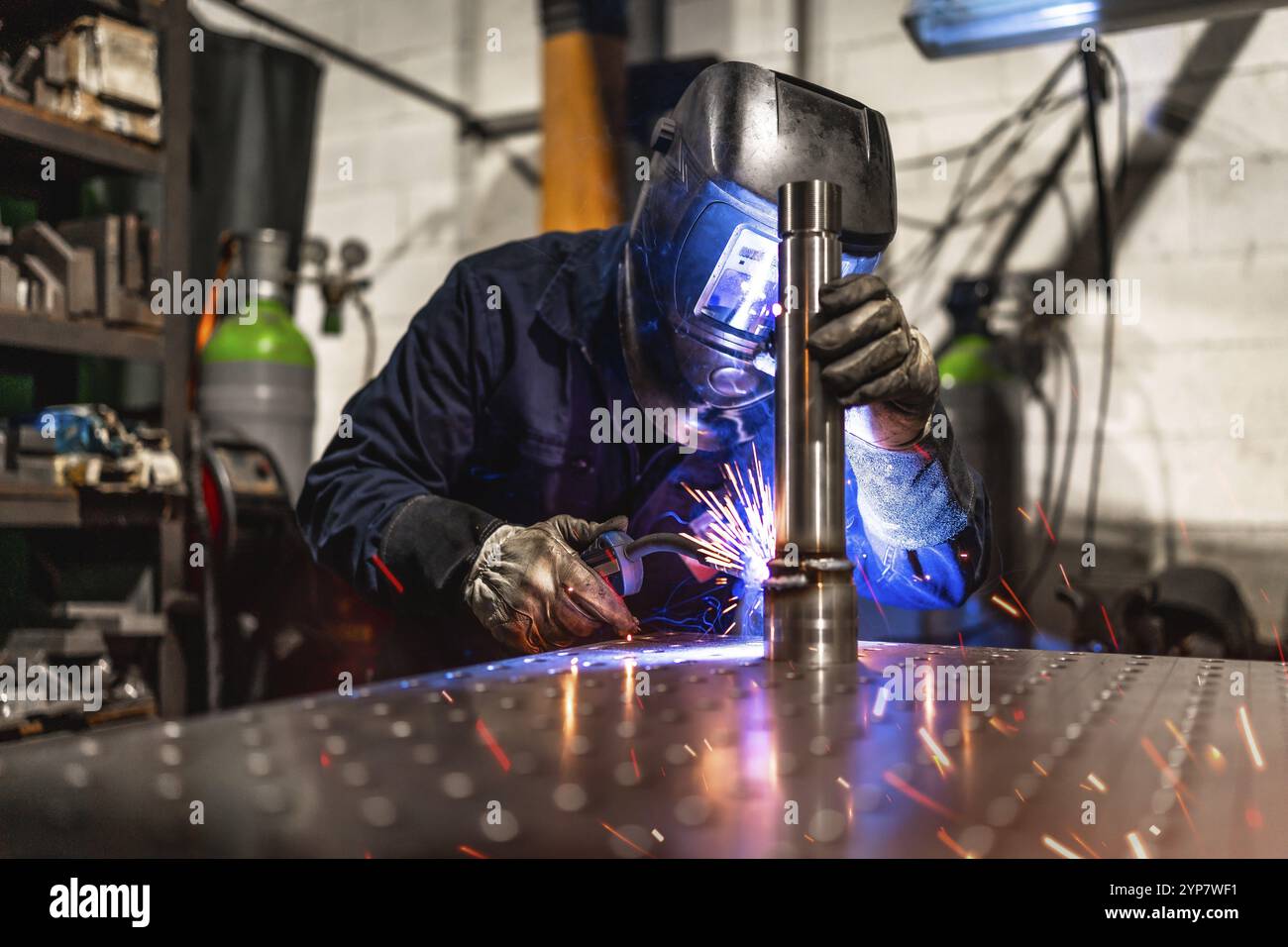 Concentrated male worker wearing protective gloves and facial mask ...