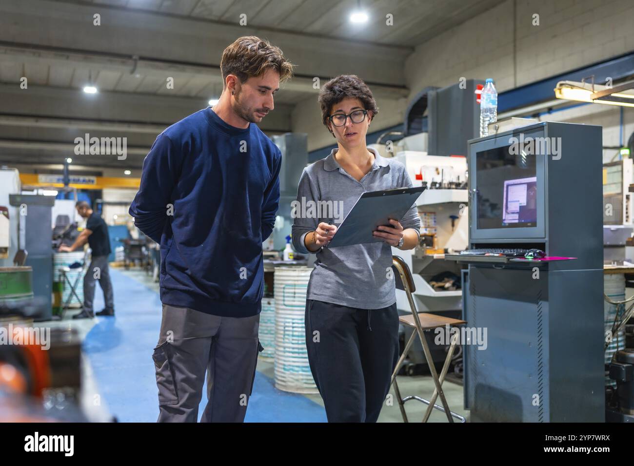 Female manager and male young engineer doing paperwork standing and ...