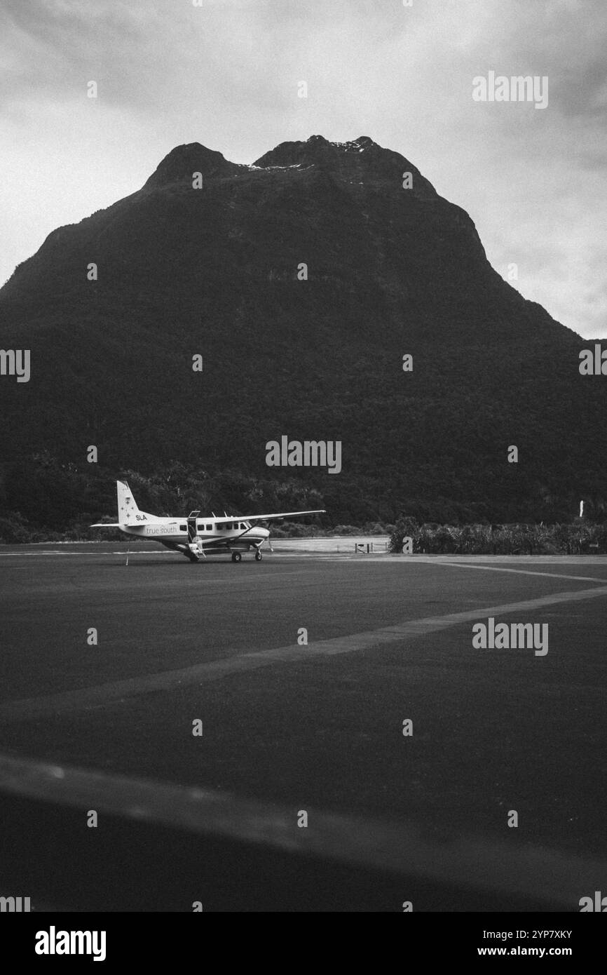 Small aeroplane at an airport in front of a high mountain, Milford ...