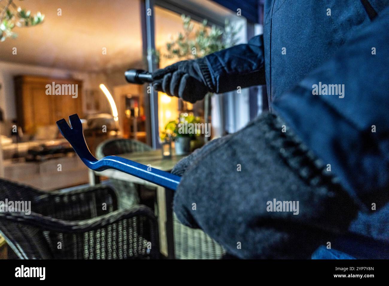 Symbolic image of a burglary, perpetrator spying on an apartment from ...