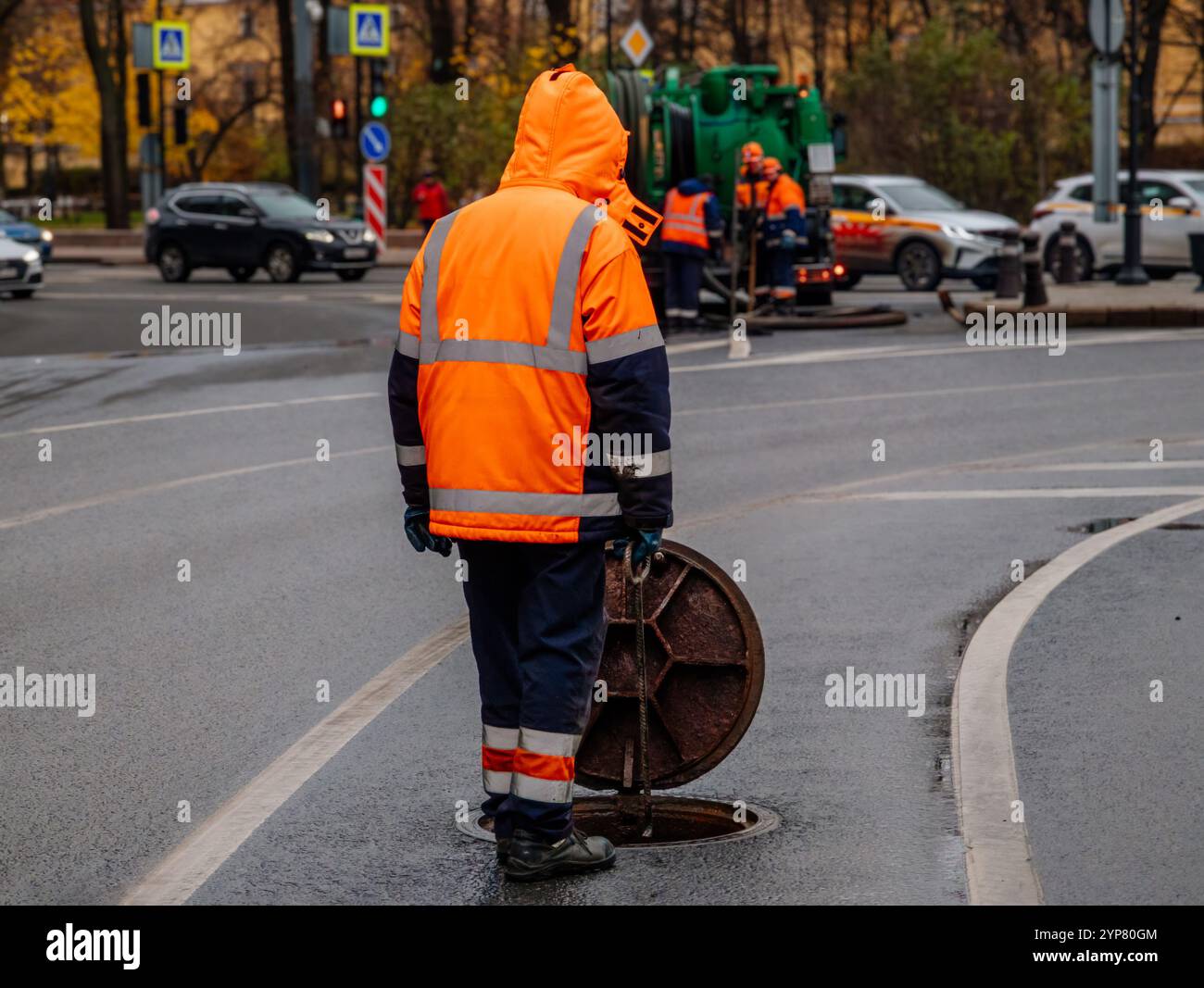 Sewer workers cleaning manhole and unblocking sewers the street ...