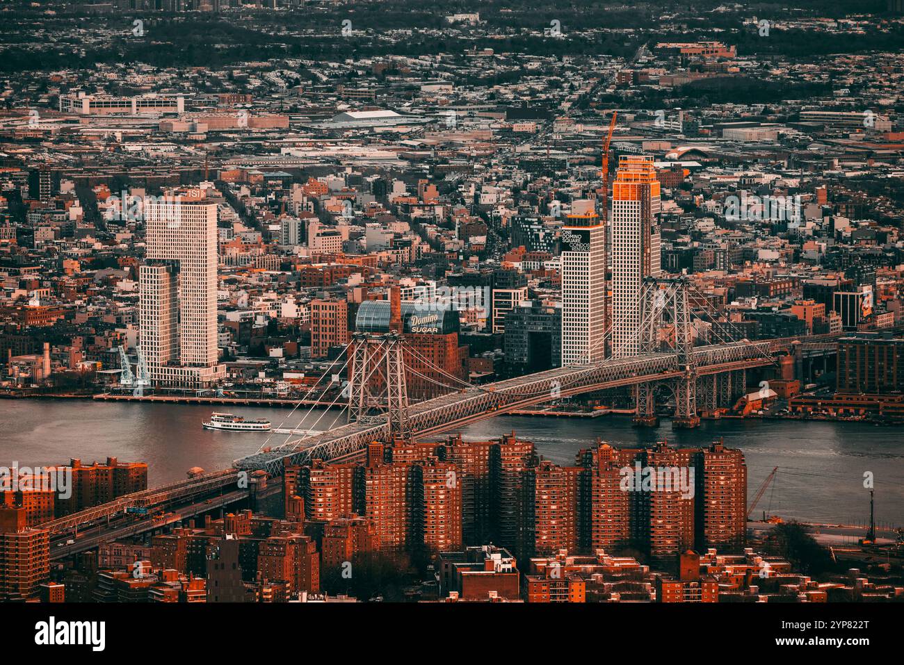 A stunning view of the Williamsburg Bridge and Brooklyn’s skyline during sunset, highlighting ...