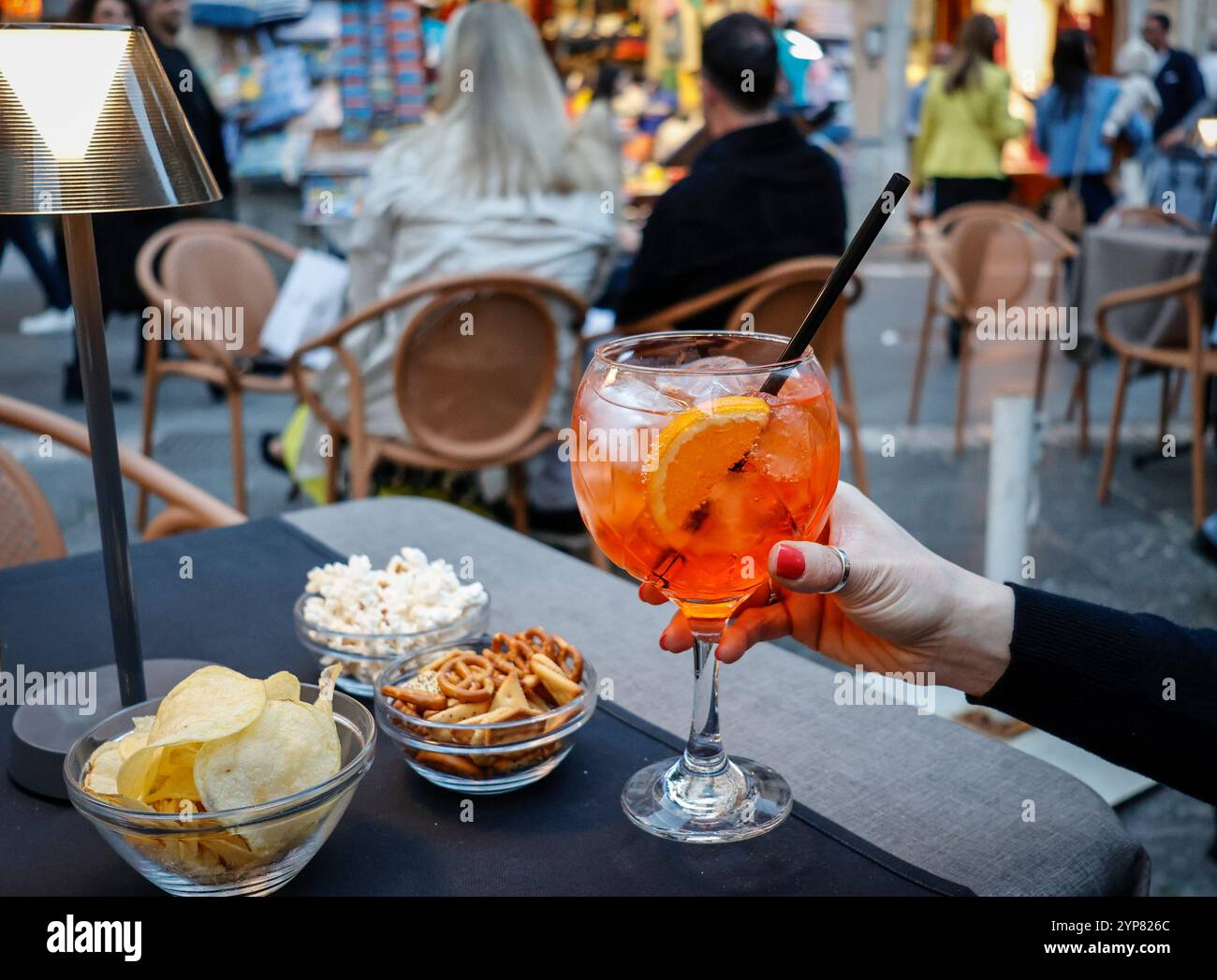 A young Lady enjoying an Aperol spritz in an Apertivo cafe / bar ...