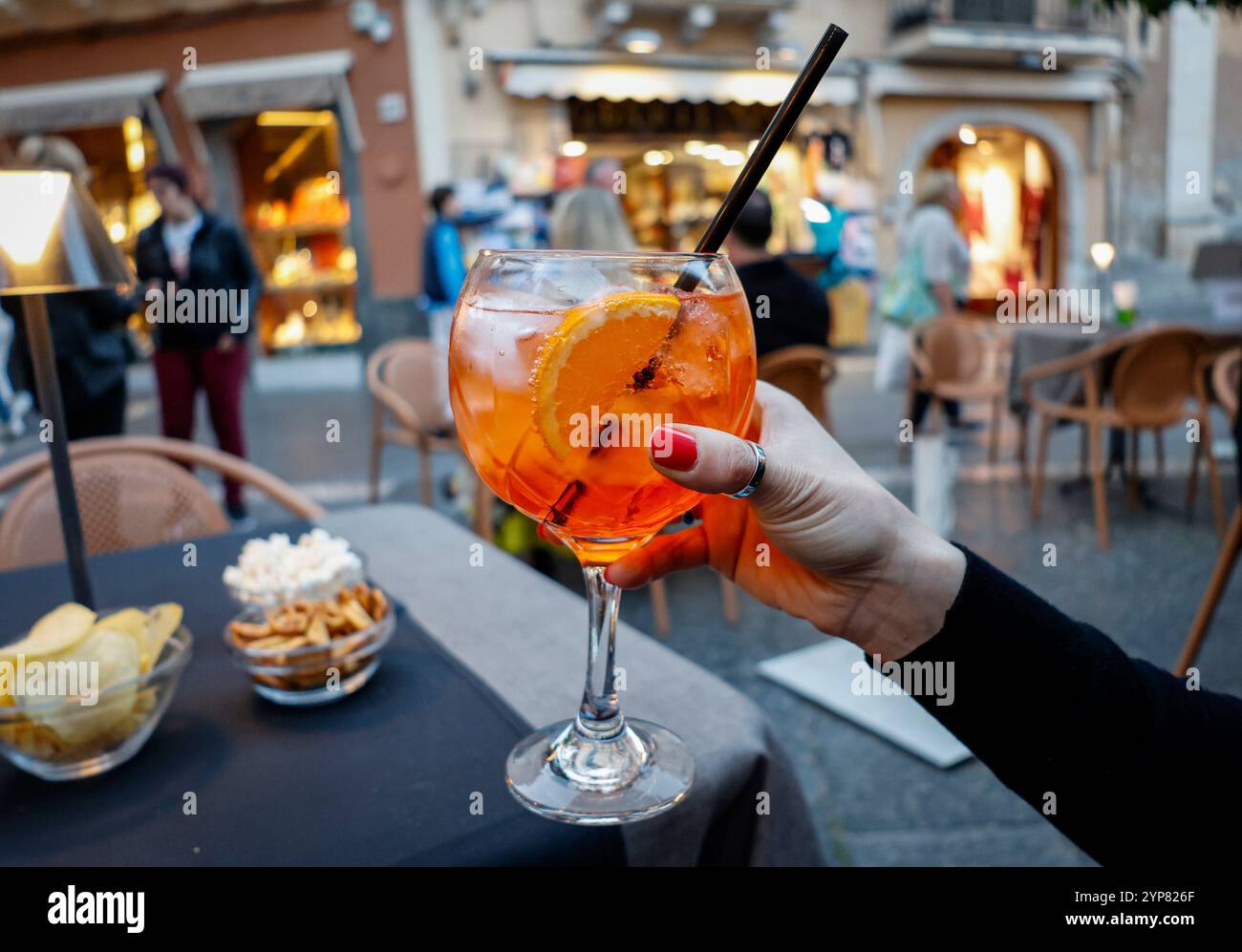 A young Lady enjoying an Aperol spritz in an Apertivo cafe / bar ...