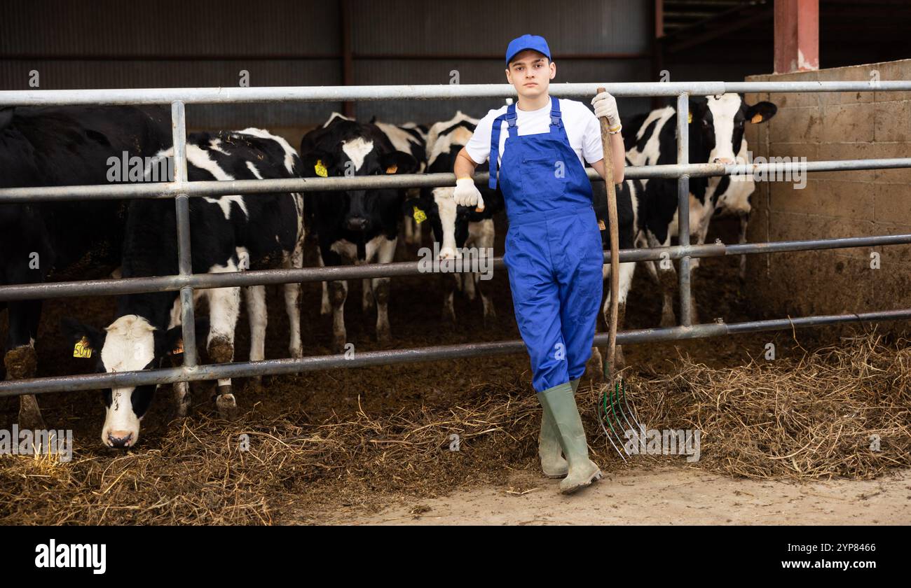 Portrait of confident European male farmer in uniform with rake during ...