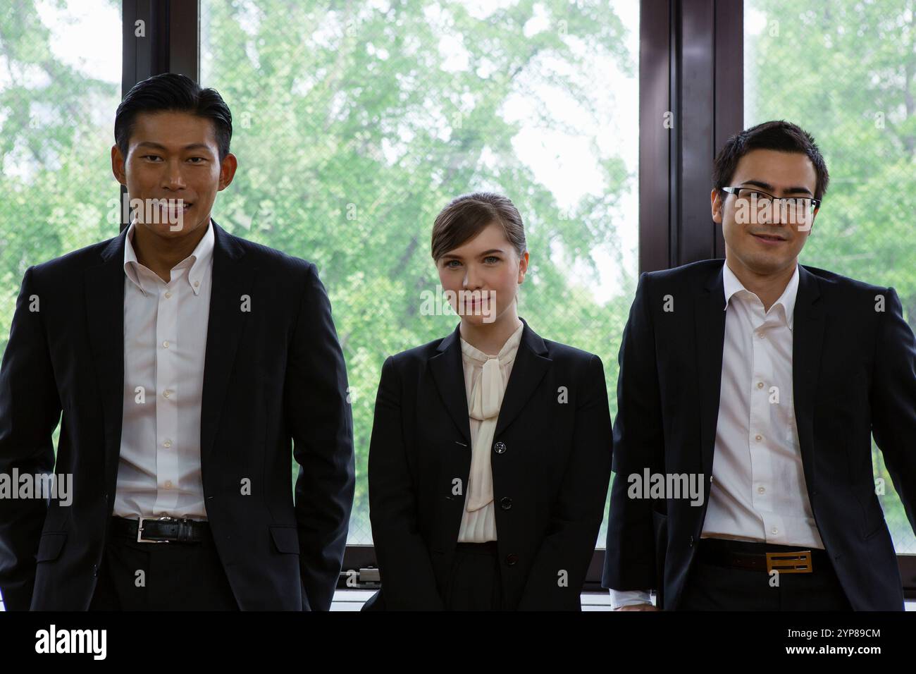 Businessperson standing by window Stock Photo - Alamy