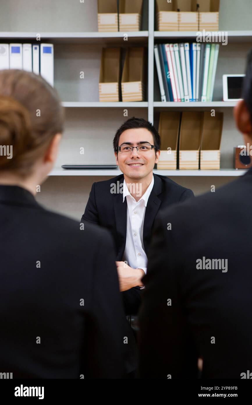 Business people sitting opposite each other Stock Photo - Alamy