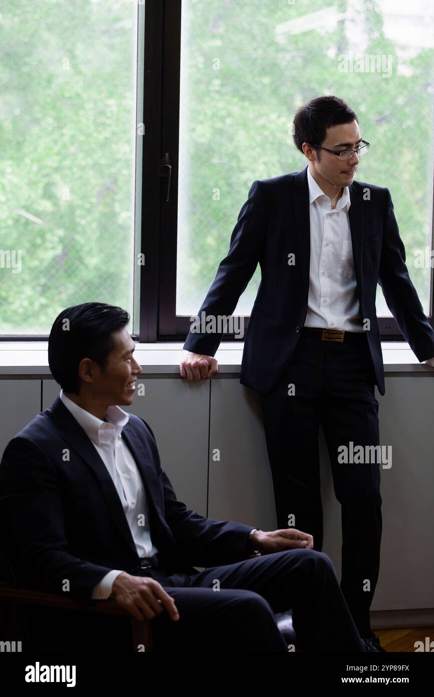 Business people talking by the window Stock Photo - Alamy