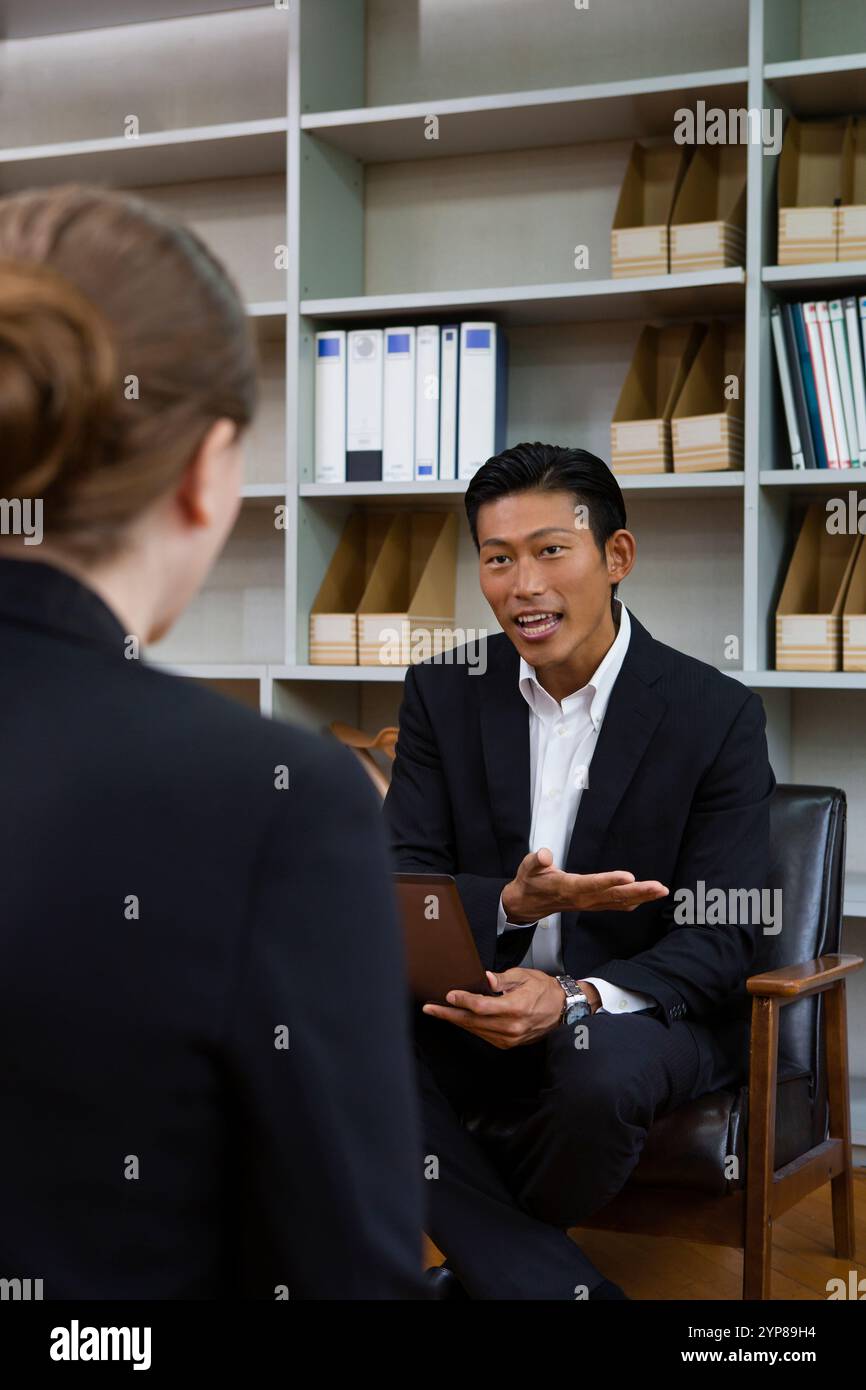Business people sitting opposite each other Stock Photo - Alamy