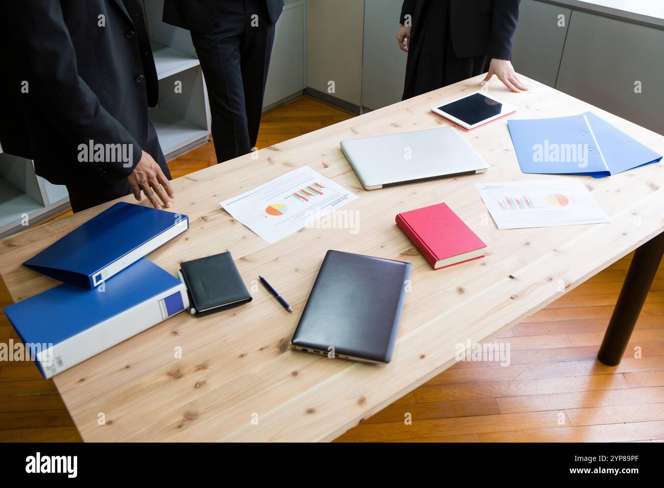 Business people talking around a desk Stock Photo - Alamy
