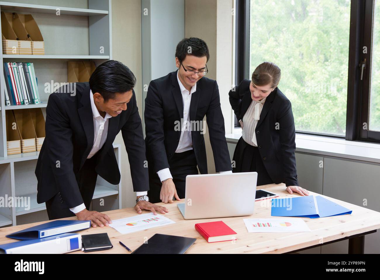 Business people talking around a desk Stock Photo - Alamy
