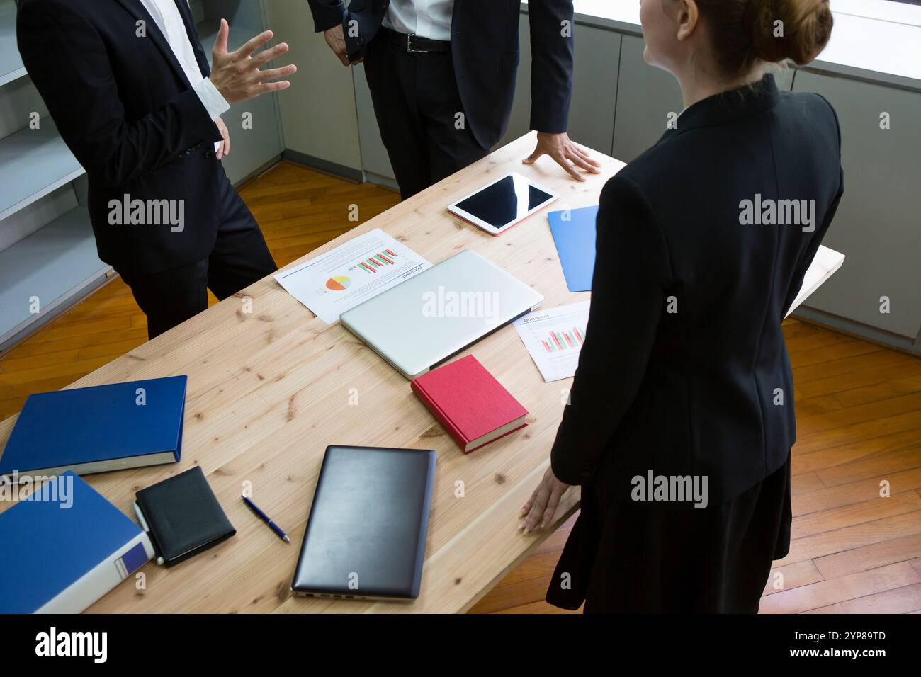 Business people talking around a desk Stock Photo - Alamy