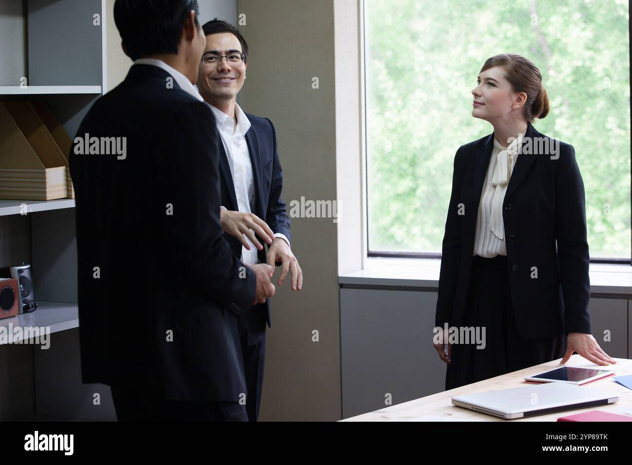 Business people talking around a desk Stock Photo - Alamy