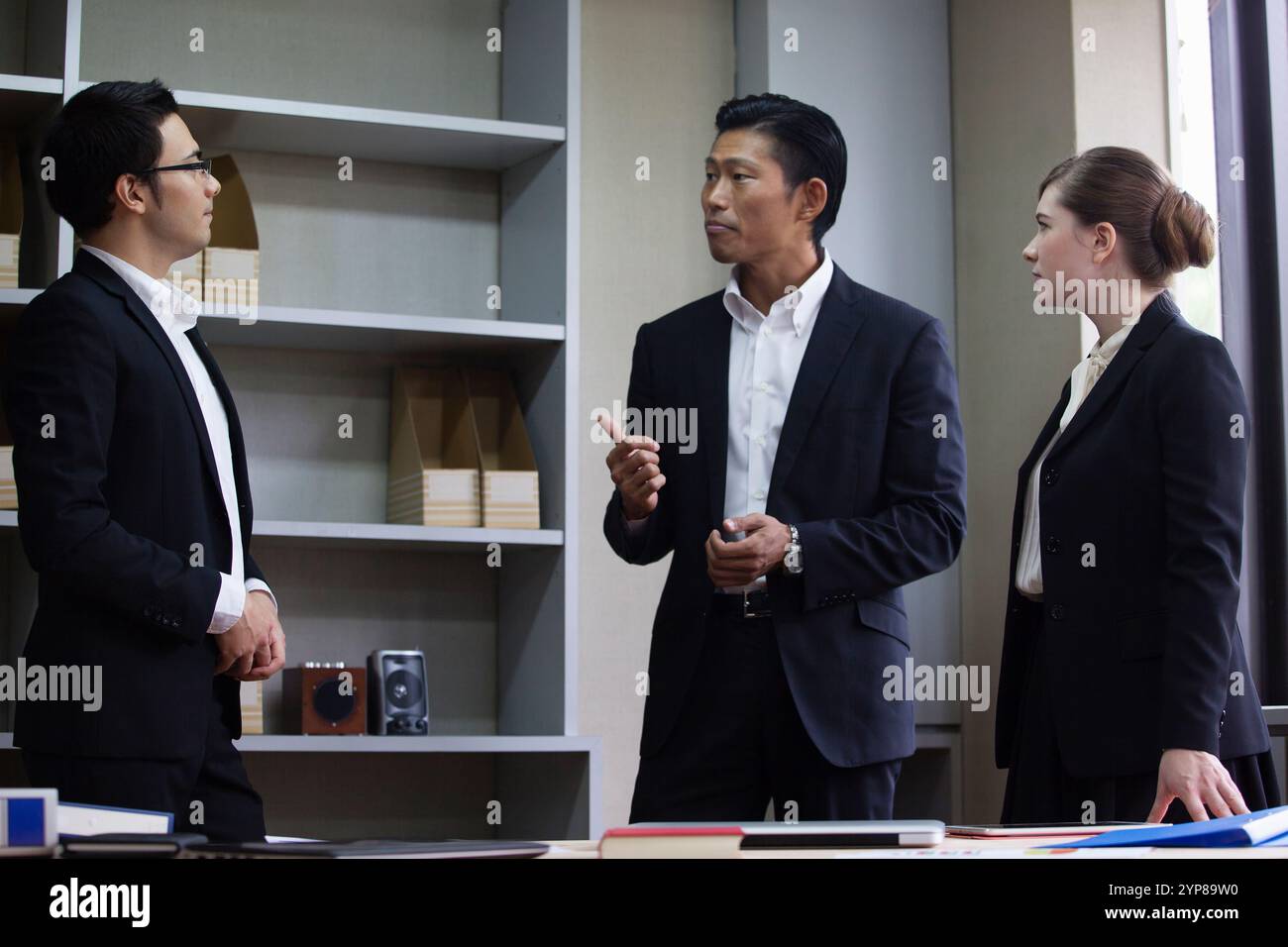 Business people talking around a desk Stock Photo - Alamy